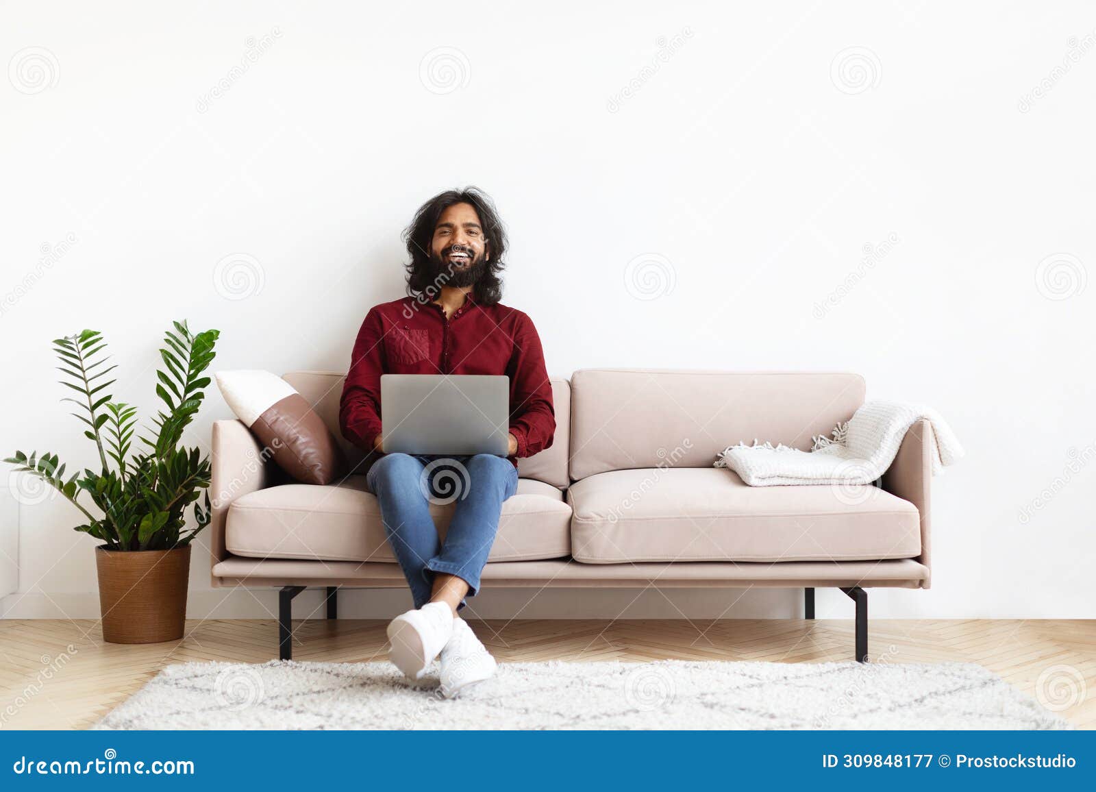 Cool Indian Guy Chilling on Couch at Home, Using Laptop Stock Image ...