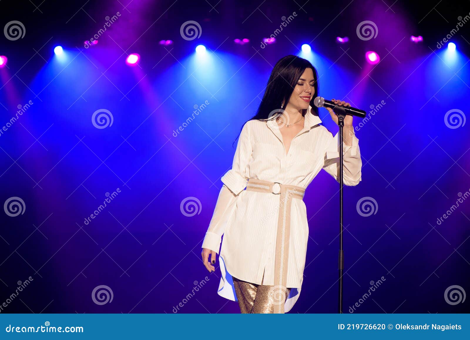 Cool Singer with Microphone on Bright Backlit Stage in Bright Blue ...