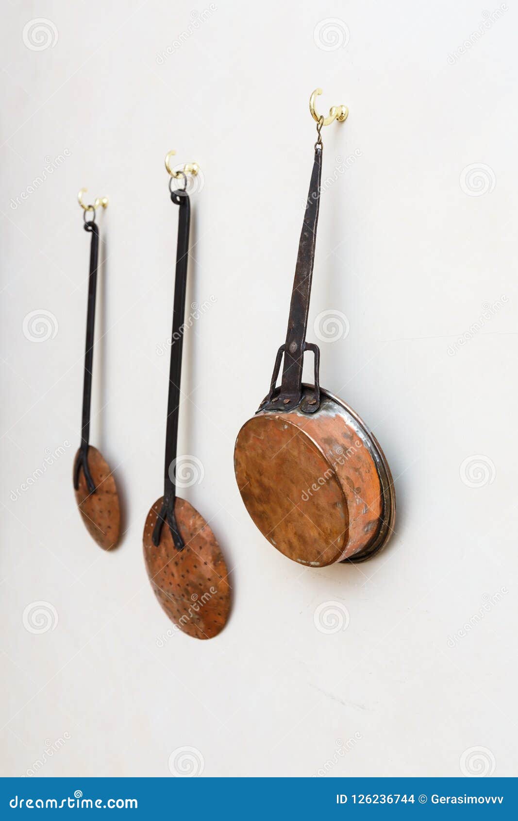 Copper Pots and Kitchen Utinsils Hanging on a White Painted Wall Stock ...