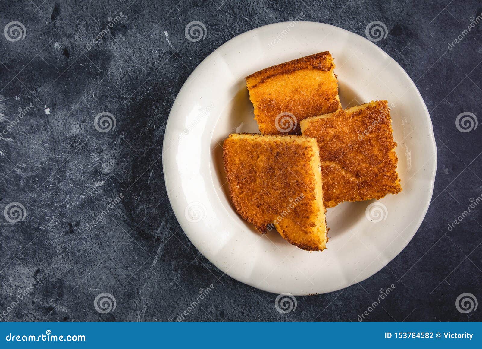 Corn Bread Squares Slices in White Plate on Dark Blue Background Stock ...