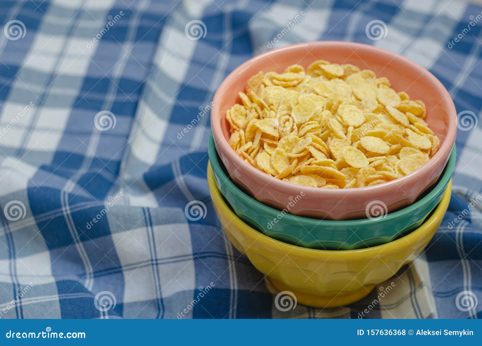 Cornflakes and Three Bowls of Different Colors, on a Plaid Napkin in ...