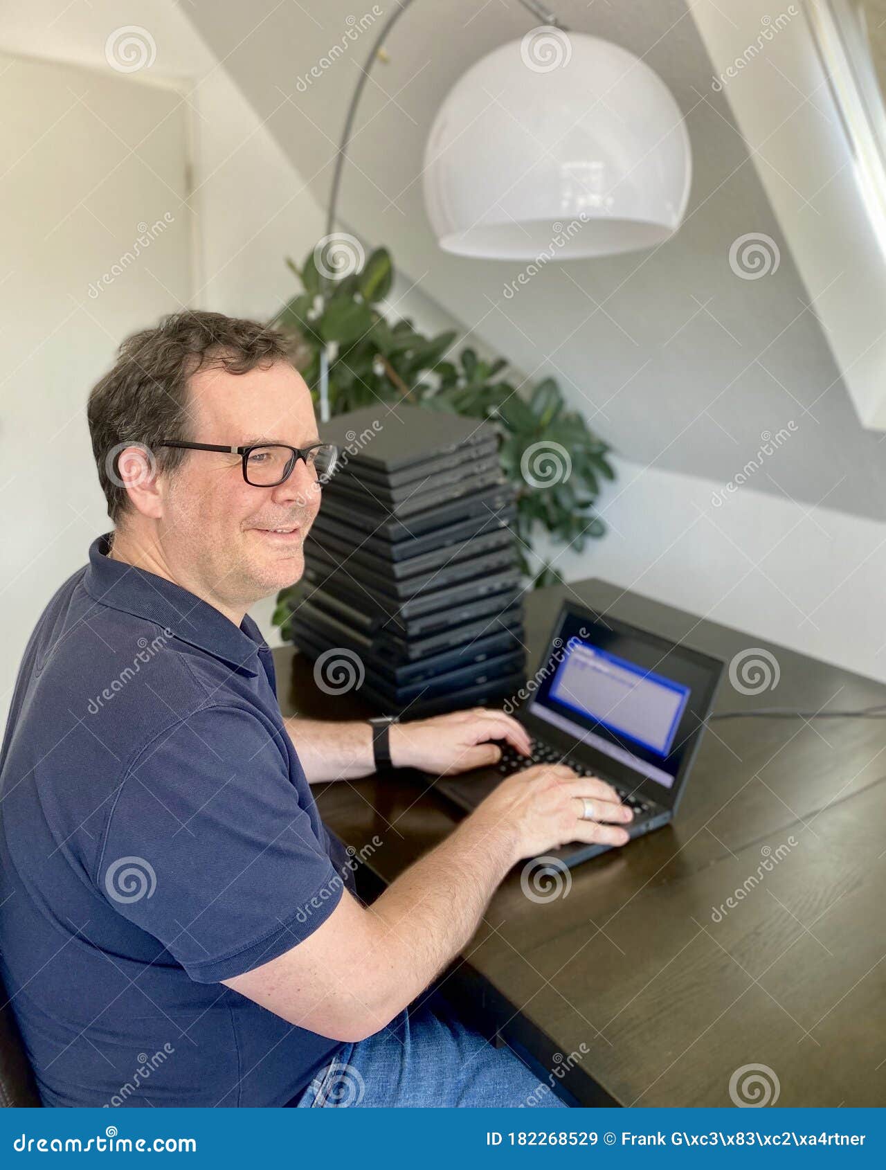 A Casually Dressed Caucasian Middle Aged Man is Installing a Laptop ...