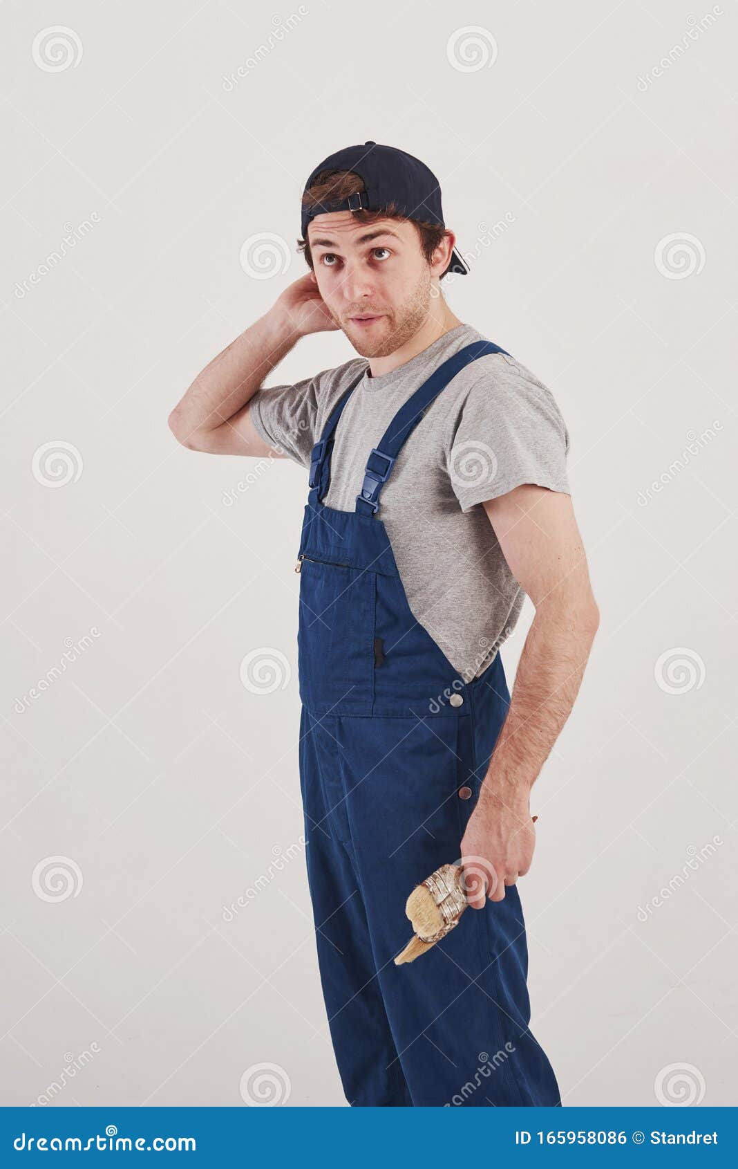 Correcting Position of the Hat. Man in Blue Uniform Stands Against ...