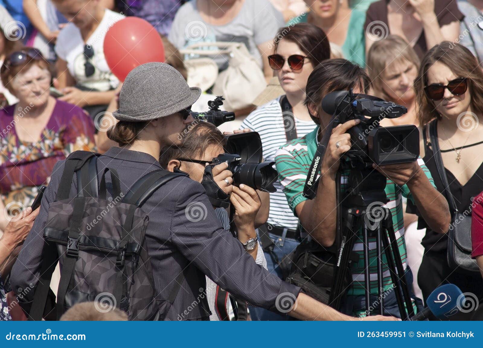 Correspondent and Camera Working in Crowd. TV Reporter Working in ...