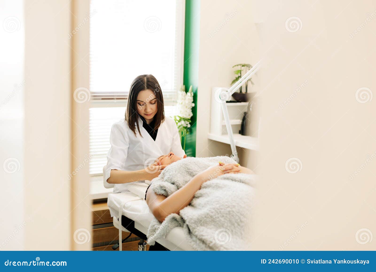 A Cosmetologist Does A Massage Procedure With A Female Face In A
