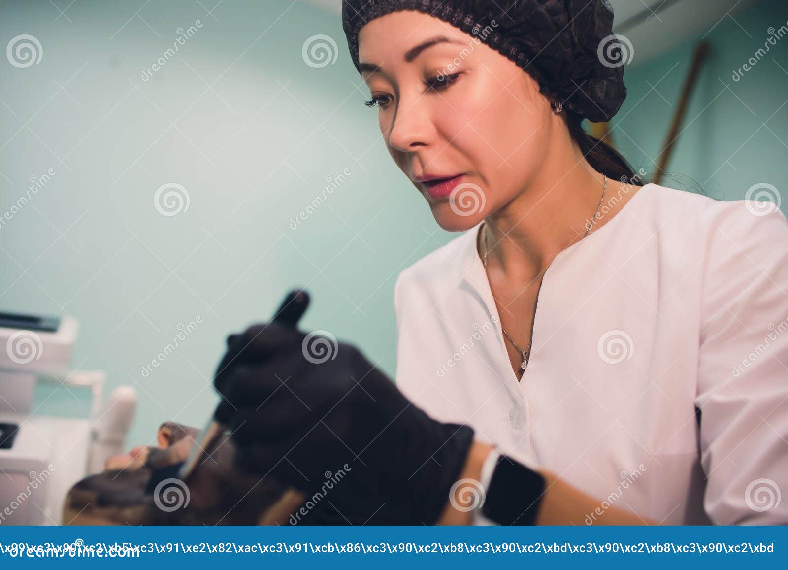 The Cosmetologist In Pink Gloves With A Brush Applies A Carbon Mask For