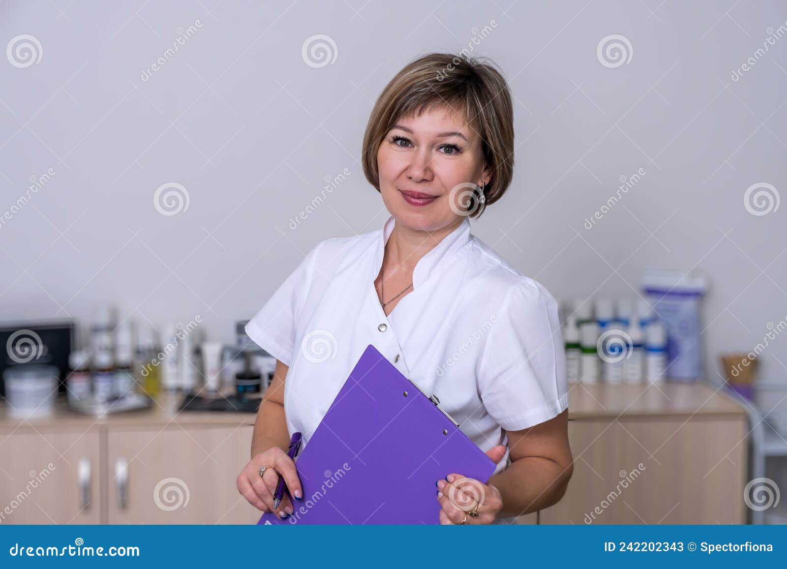 Cosmetologist Standing with a Purple Folder and Smiling in Modern ...