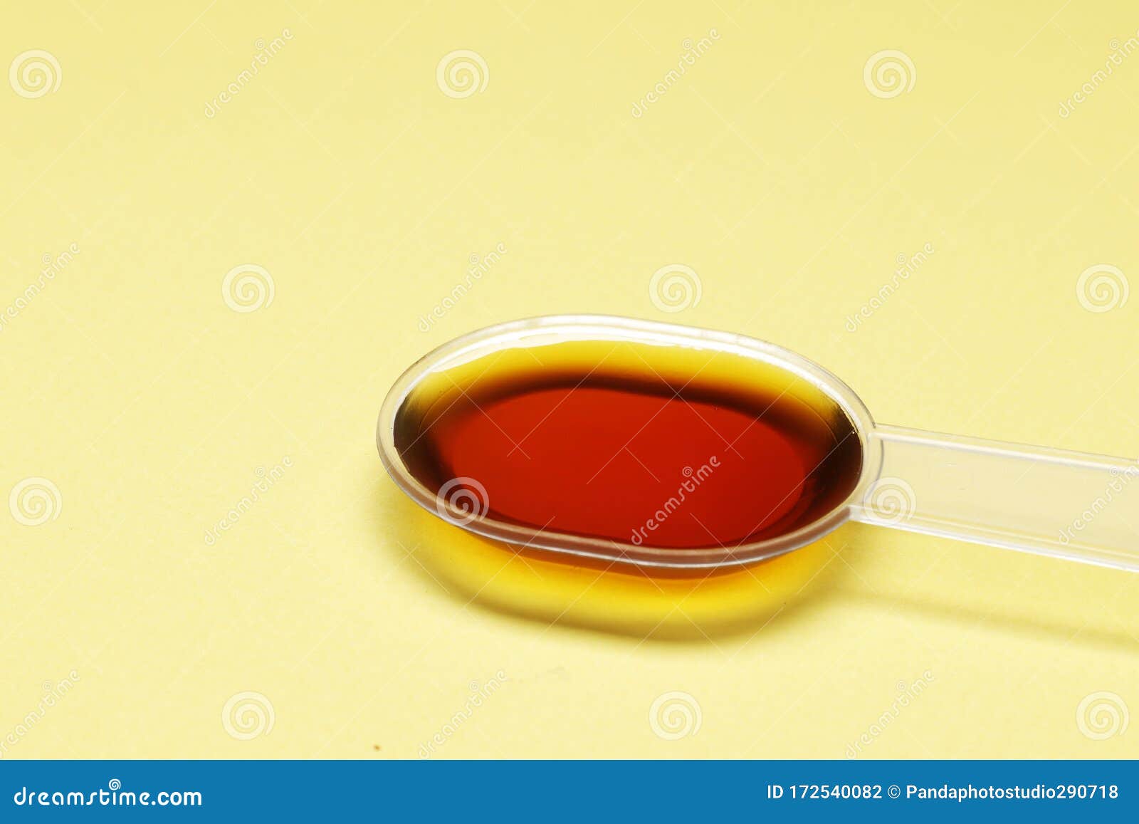 Cough syrup on a yellow stock photo. Image of glass - 172540082