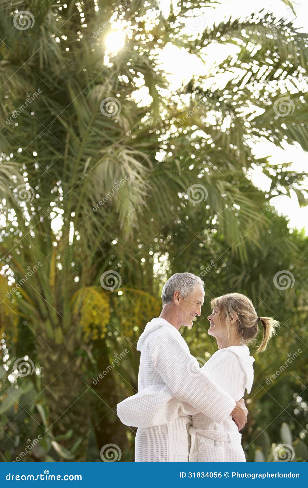Couple in Bathrobes Hugging by Palm Trees Stock Photo - Image of ...