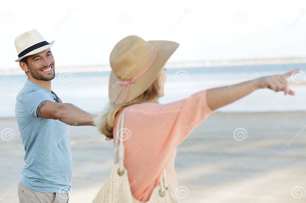 Couple on Beach Pointing into Distance Stock Image - Image of outdoors ...