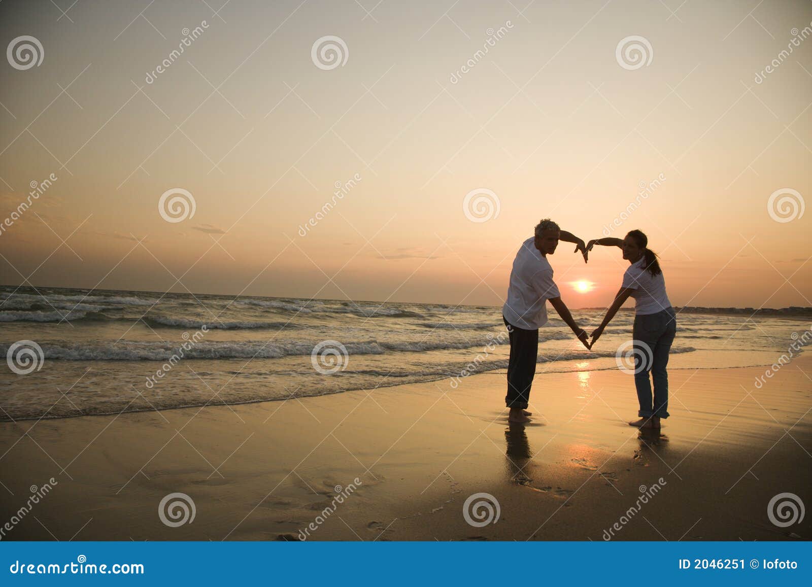 Couple on beach at sunset. stock image. Image of tide - 2046251