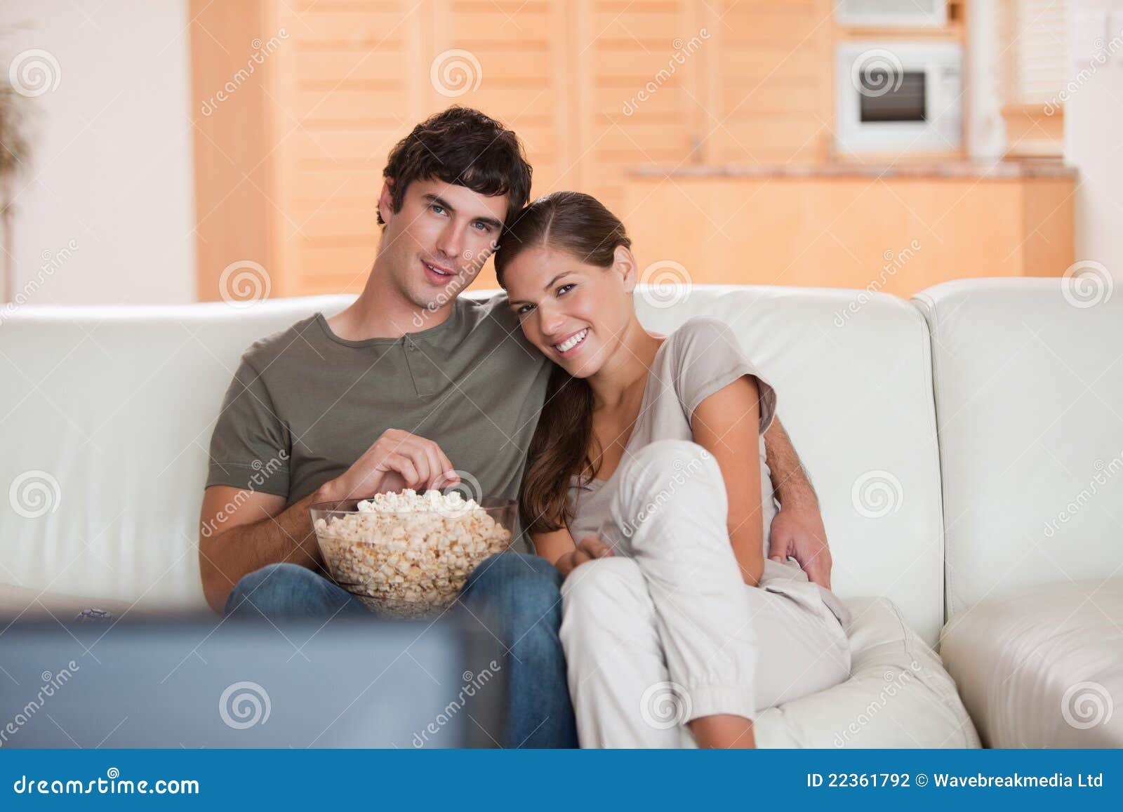 Couple With Bowl Of Popcorn Watching A Movie On The Sofa Stock ...