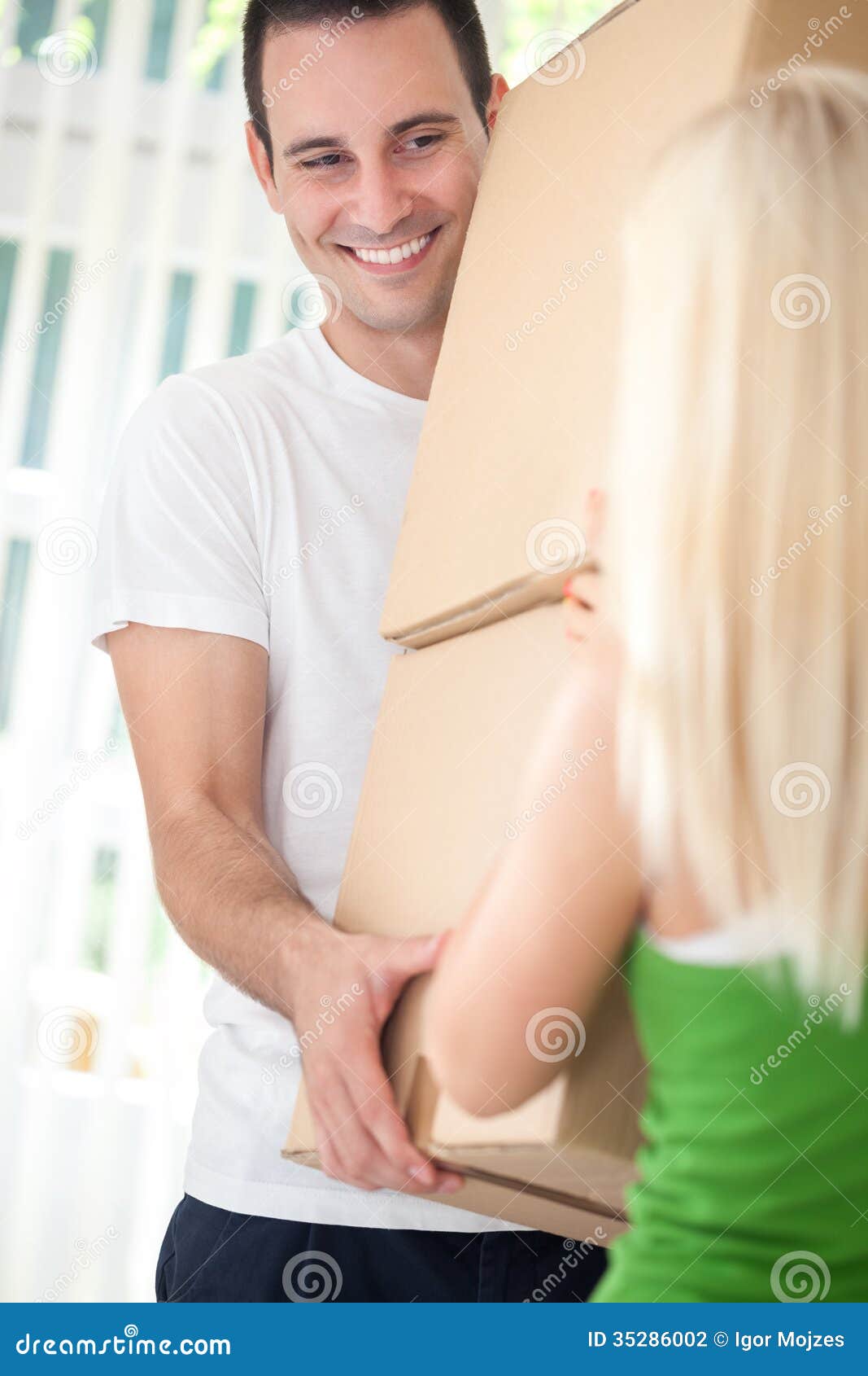 Couple with Boxes Moving into New Home, Smiling Stock Photo - Image of ...