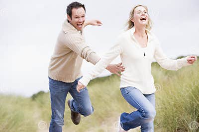 Couple Chasing One Another through Dunes Stock Photo - Image of ...