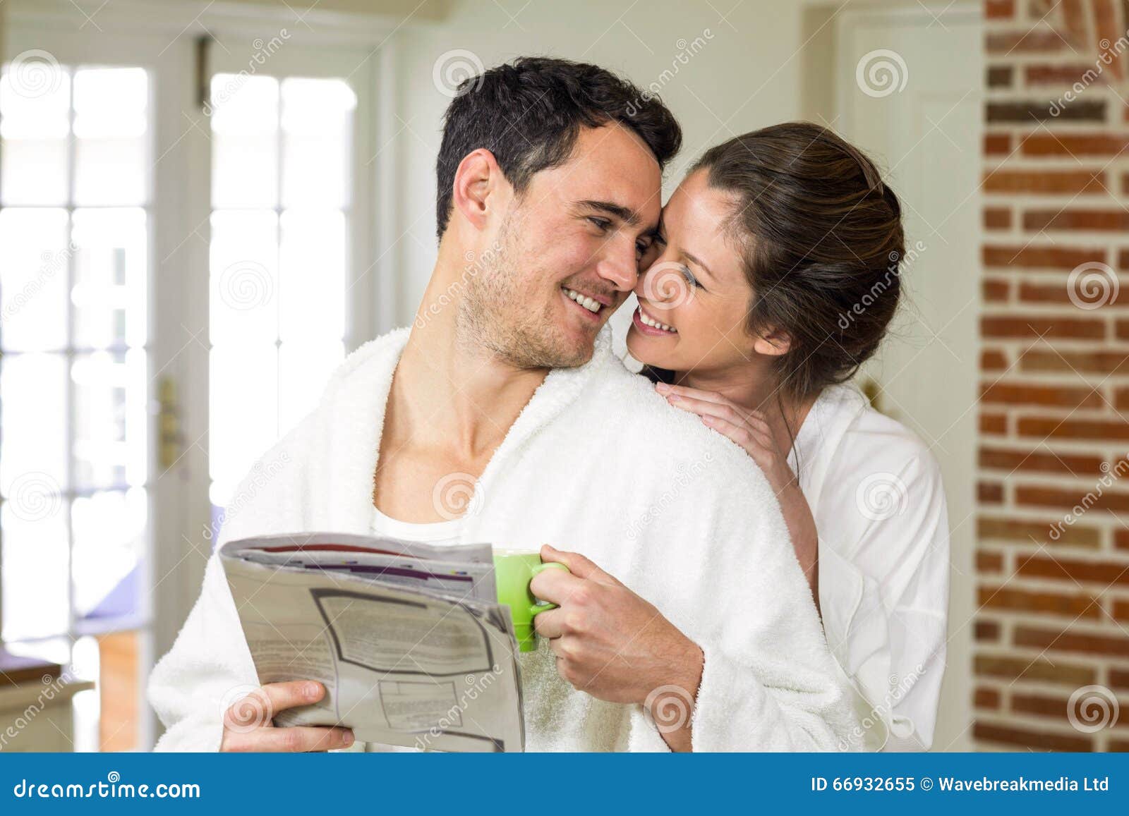 Couple Cuddling while Having Tea and Reading Newspaper Stock Image ...