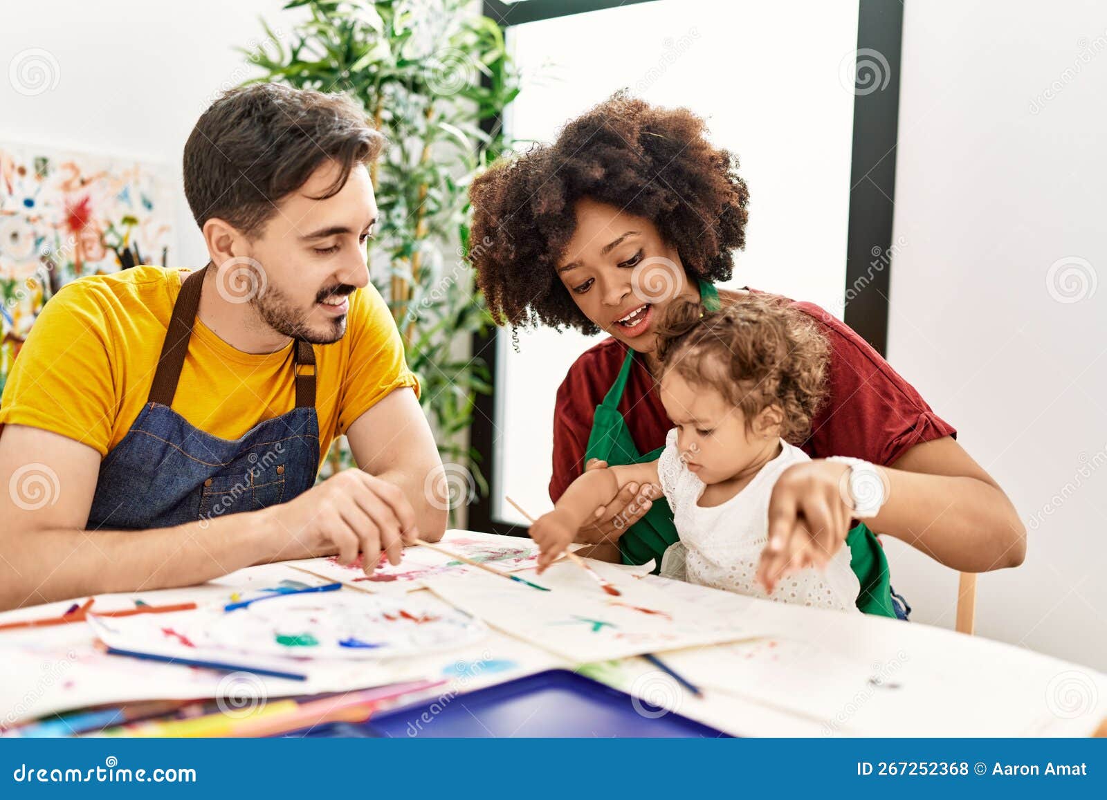 Couple and Daughter Smiling Confident Drawing at Art Studio Stock Photo ...