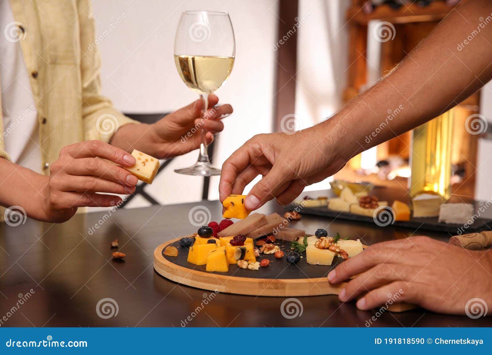 Couple with Different Types of Delicious Cheeses at Table Indoors Stock ...