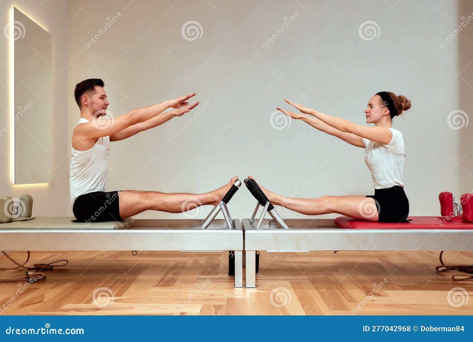 Couple Doing Pilates on a Reformer, Group Pilates Training in a Studio ...