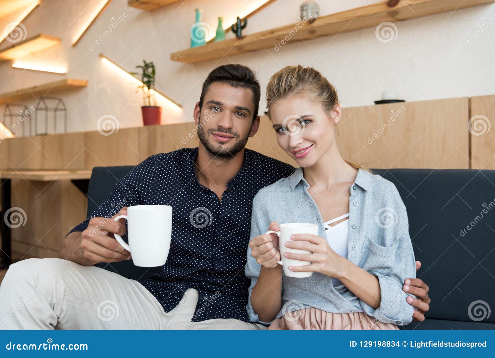 Happy Young Couple Drinking Coffee And Smiling At Camera Stock Photo ...