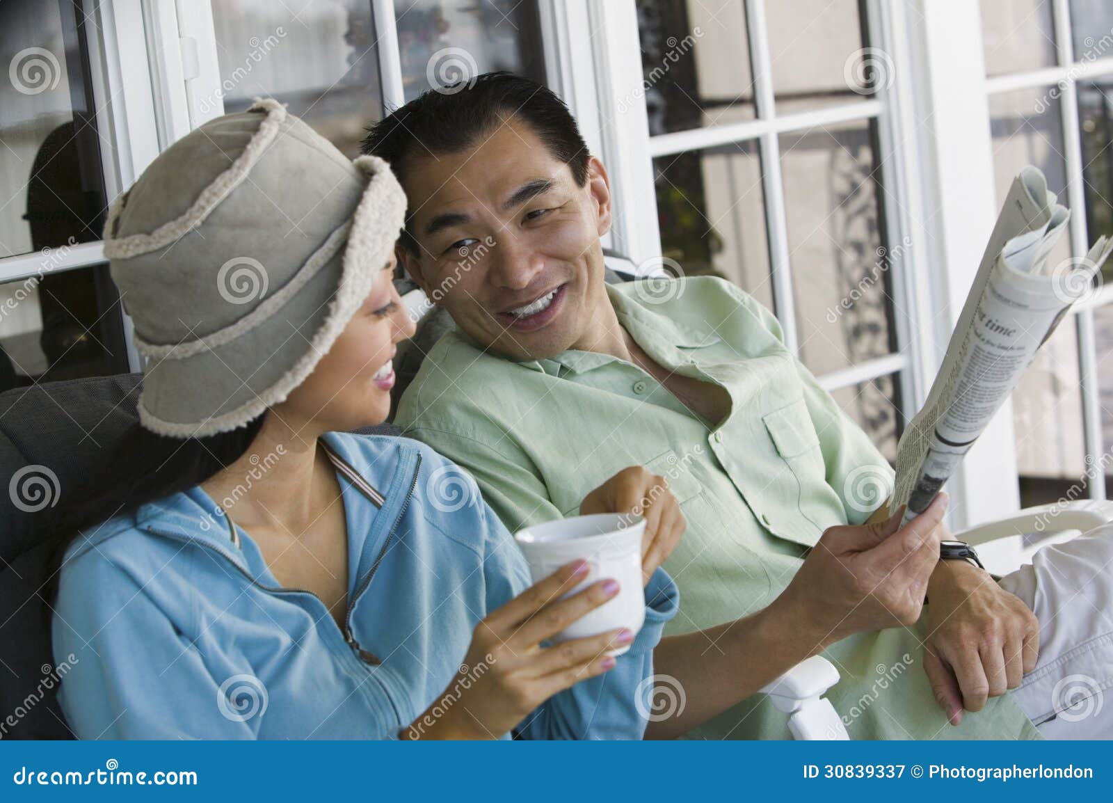Couple Drinking Coffee and Reading Newspaper on Porch Stock Image ...