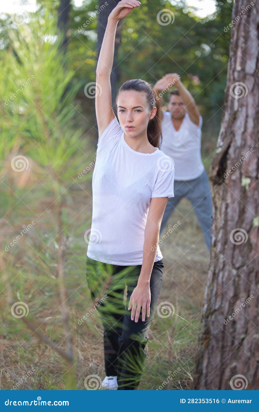 Couple Exercising Outdoors Each in Different Stretching Position Stock ...