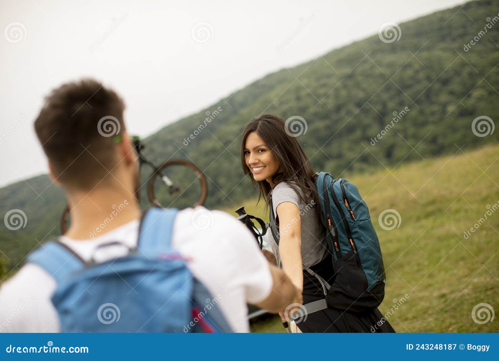 Couple of Hikers with Backpacks Starting a Walk through the Fields ...