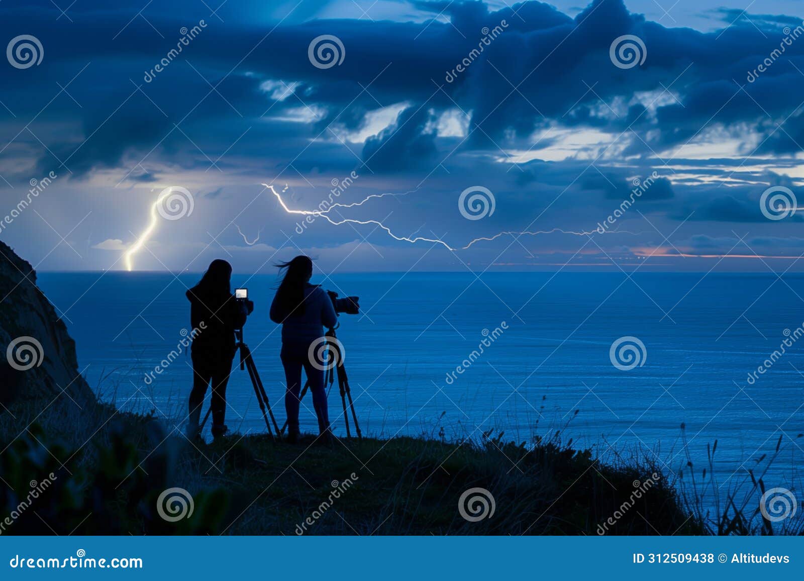 Couple on Hillside with Camera Watching Lightning Over Ocean Stock ...