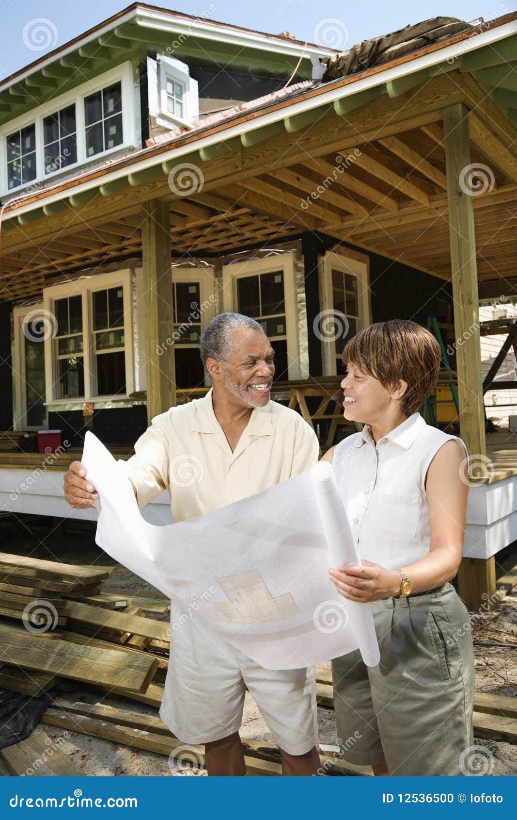 Couple Holding Building Plans Stock Photo - Image of african, looking ...