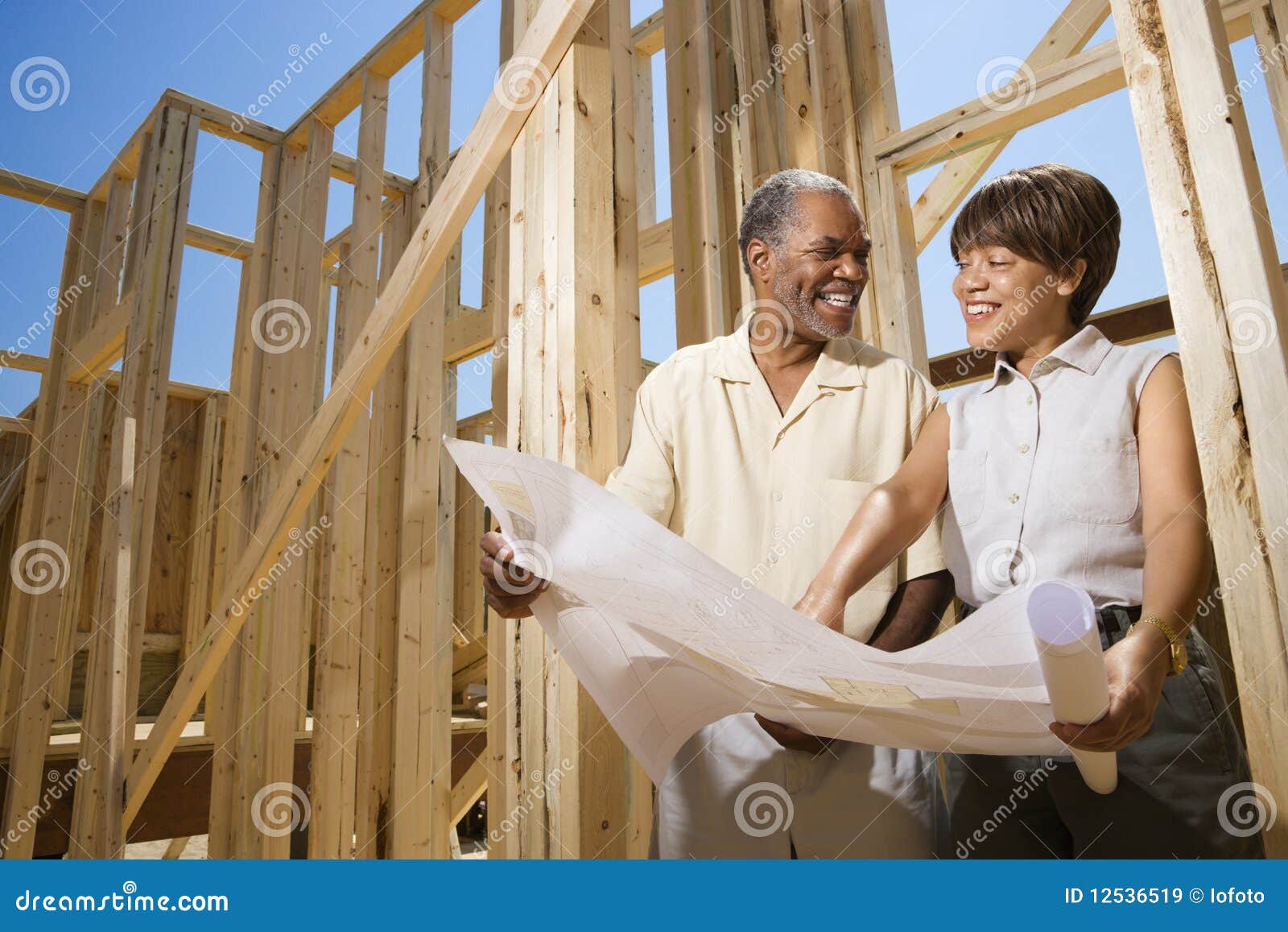 Couple Holding Building Plans on Construction Site Stock Image - Image ... Couple Holding Building Plans on Construction Site Stock Image - Image ...