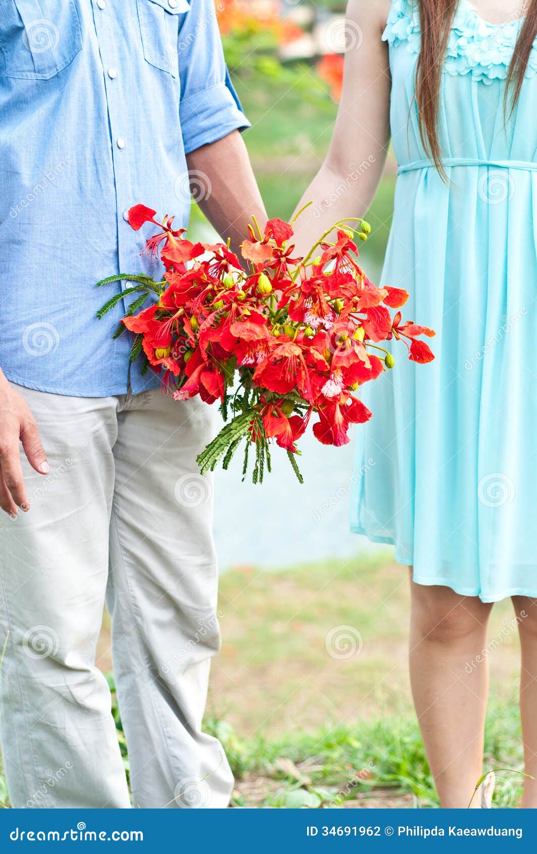 Couple holding red flowers stock photo. Image of girl - 34691962