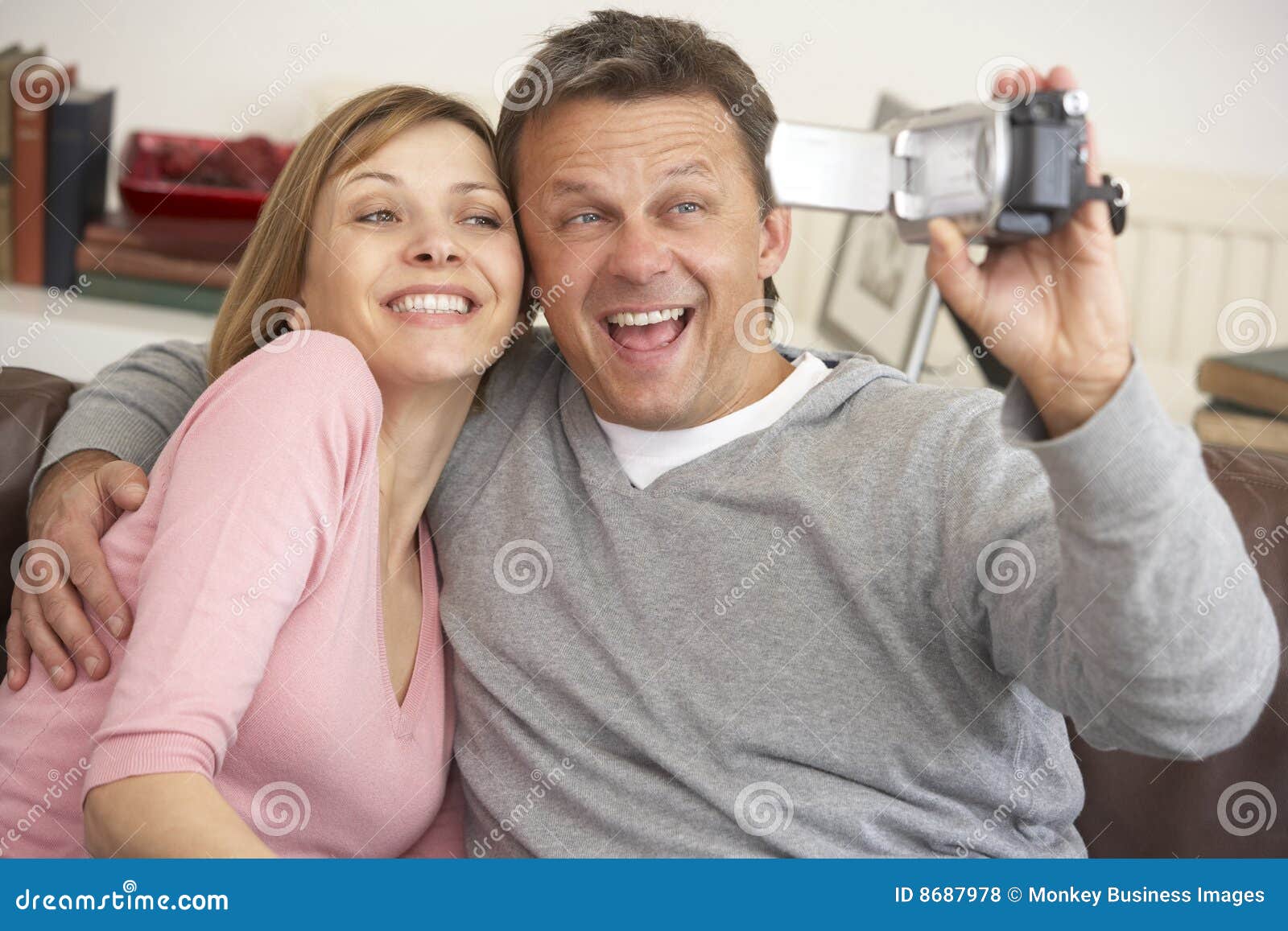 Couple Holding a Video Camera Stock Photo - Image of people, sitting ...