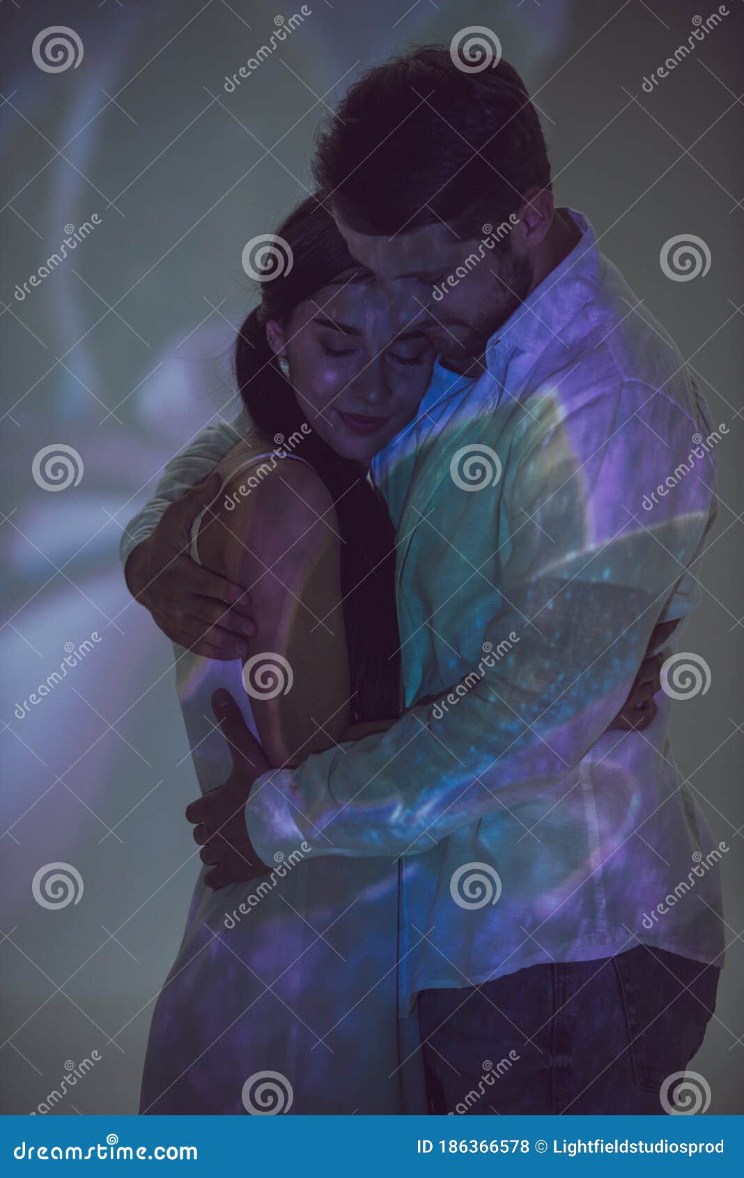 Couple Hugging while Standing in Light from Projector Stock Photo ...