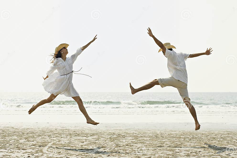 Couple Jumping on Beach stock photo. Image of beach, jumping - 5251866