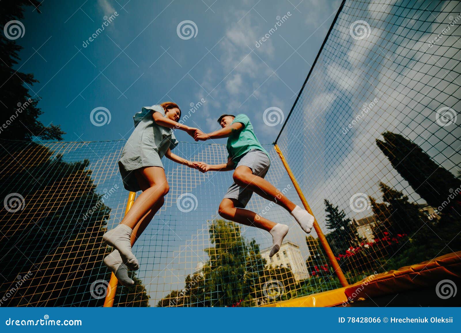 Couple Jumping on Trampoline in the Park Stock Photo - Image of front ...