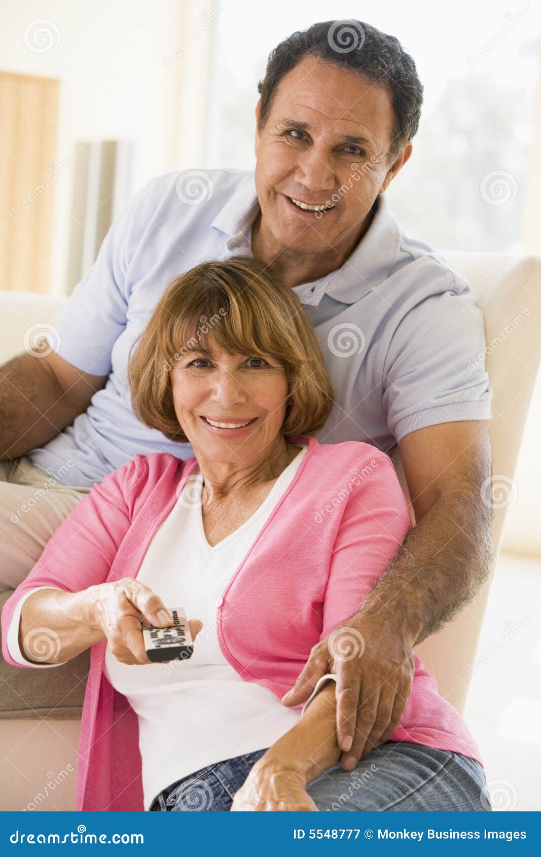 Couple in Living Room with Remote Control Smiling Stock Image - Image ...