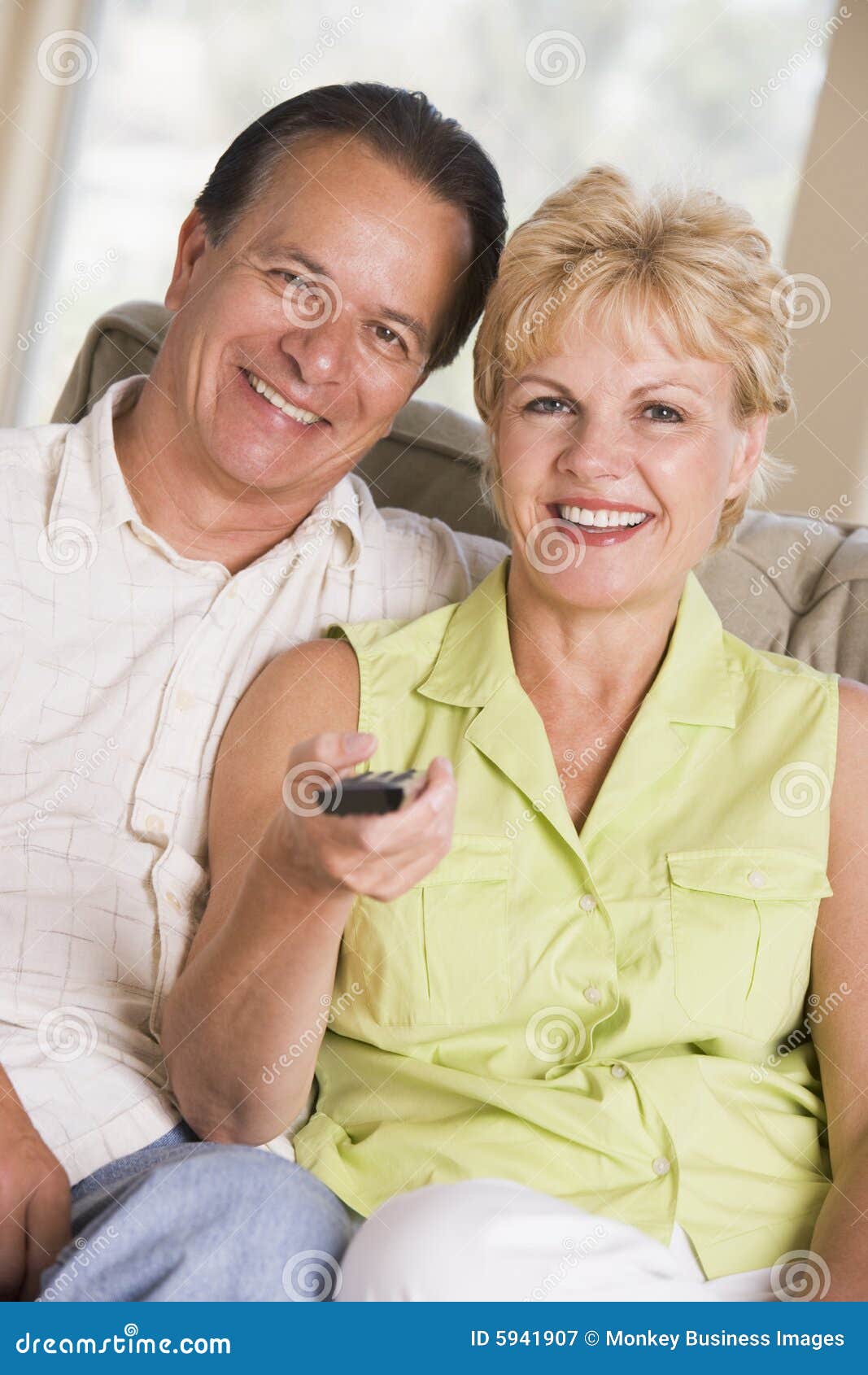 Couple in Living Room Using Remote Control Smiling Stock Image - Image ...