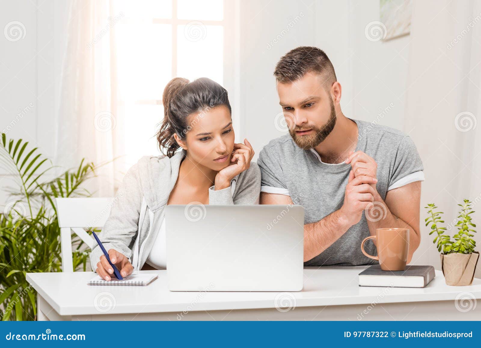 Couple Looking at Laptop Screen while Working at Home Together Stock ...