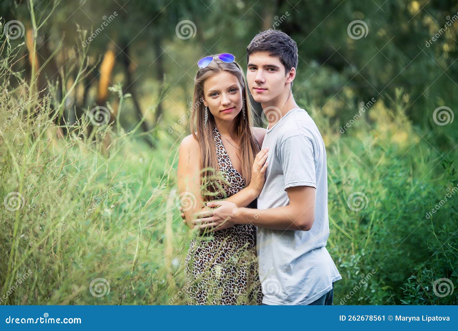 Couple In Love Hugs While Standing Among The Grasses In The Summer At