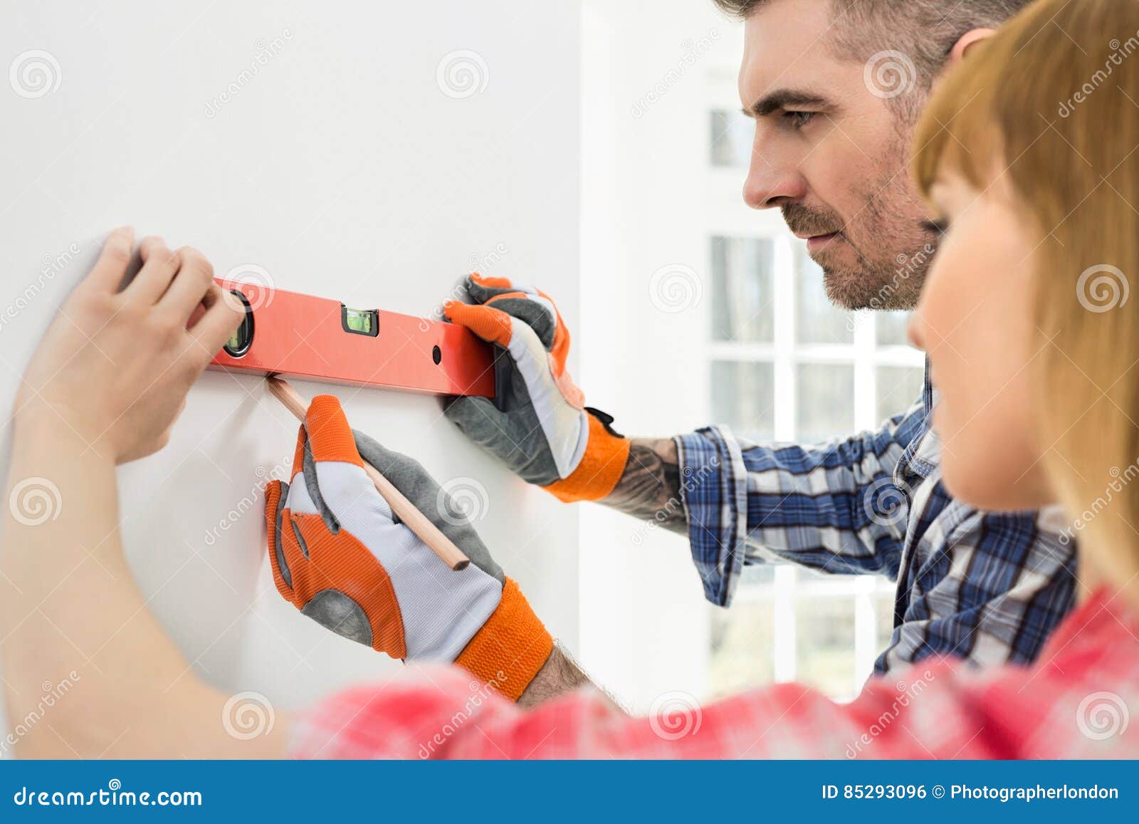 Couple Marking on Wall with Level in New House Stock Photo - Image of ...