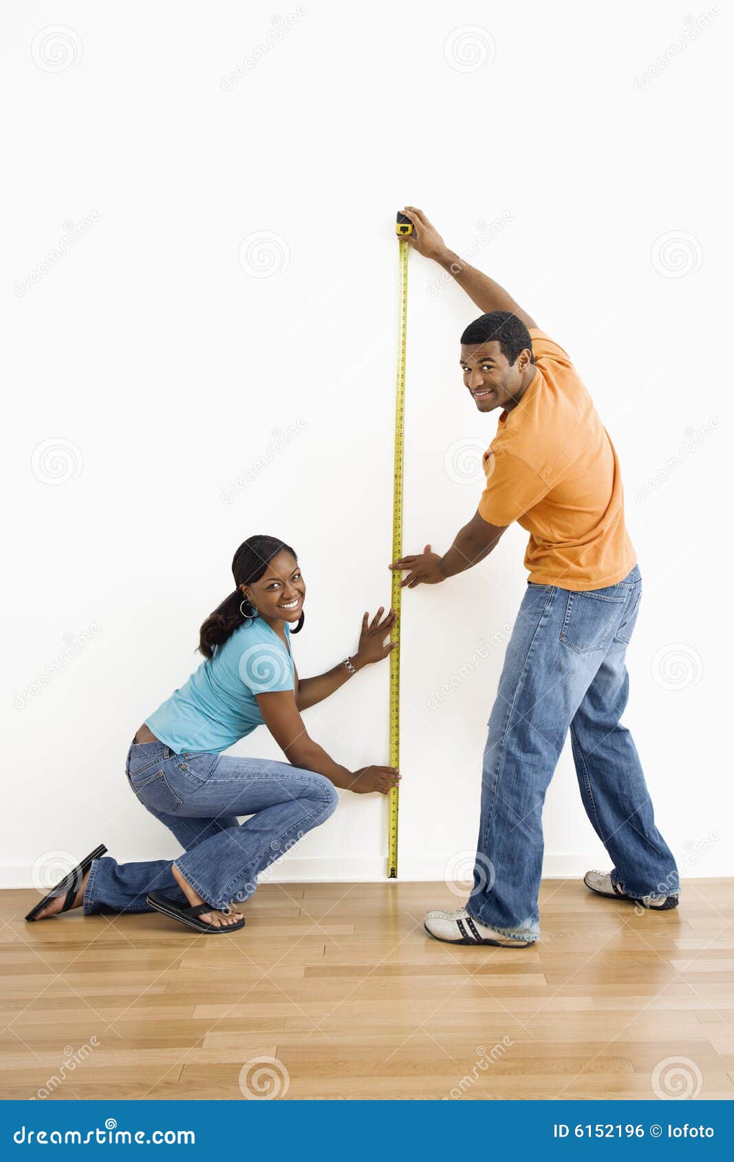 Couple measuring wall. stock photo. Image of length, photograph - 6152196