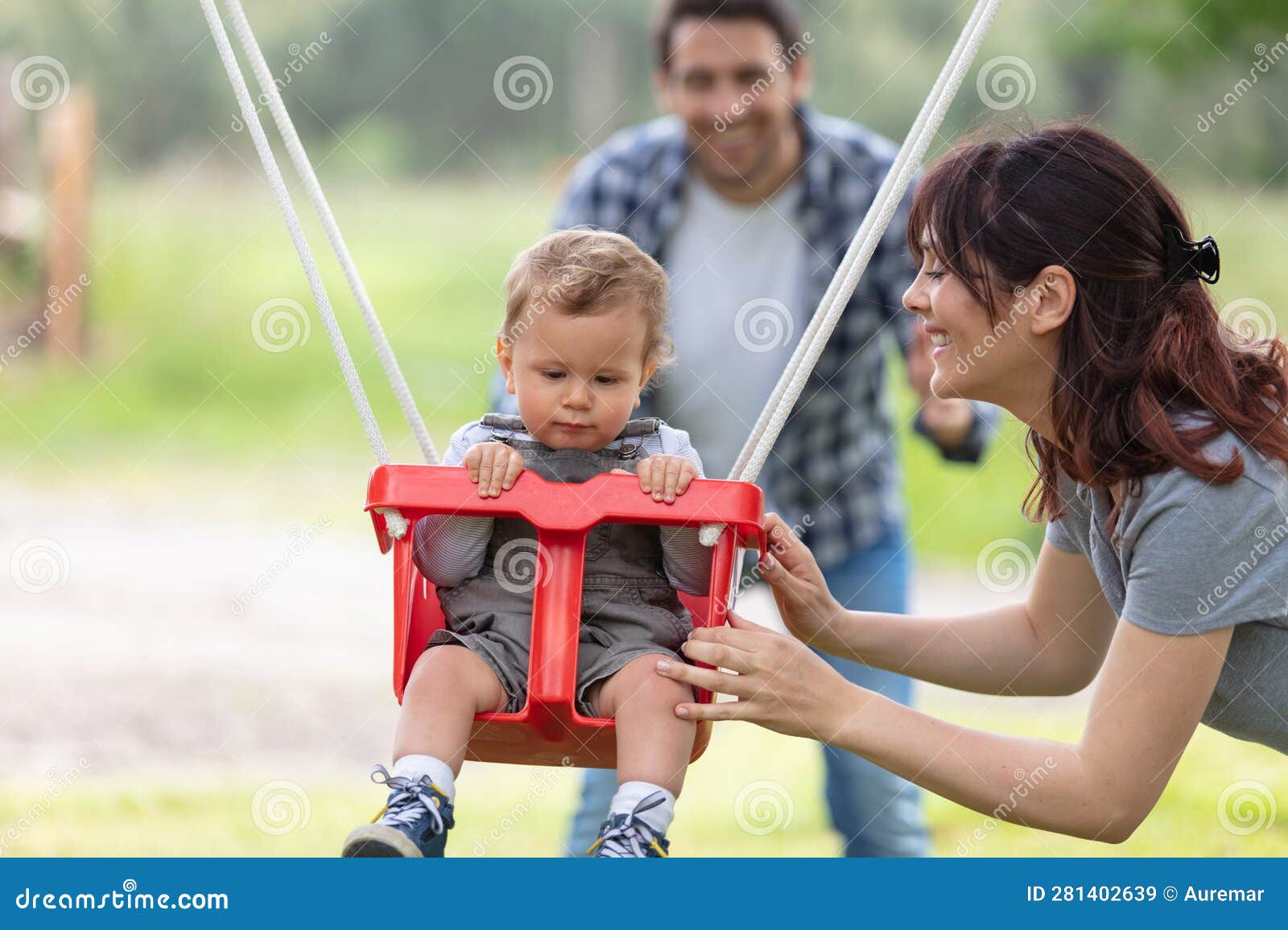 Couple Pushing Baby on Swing Stock Image - Image of frontview ...