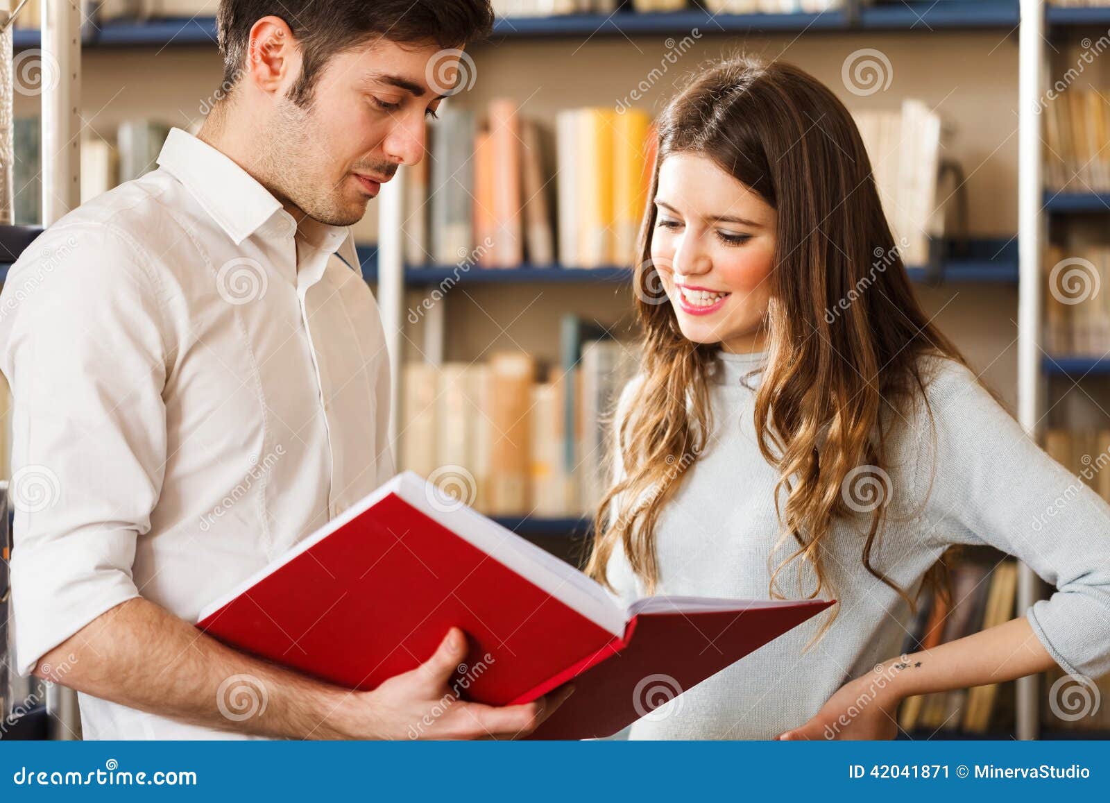 Couple Reading a Book in a Library Stock Image - Image of preparing ...