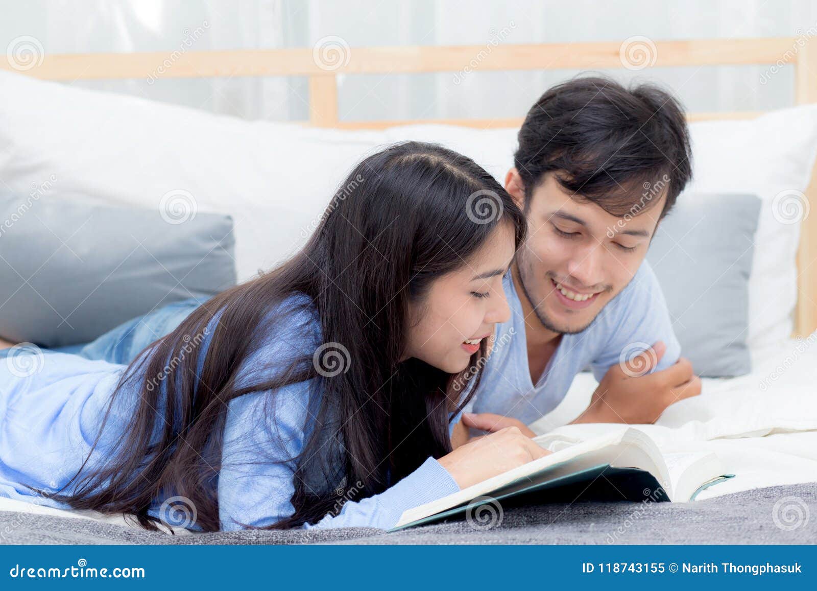 Couple Reading A Book Together In Bedroom On The Morning With Happiness