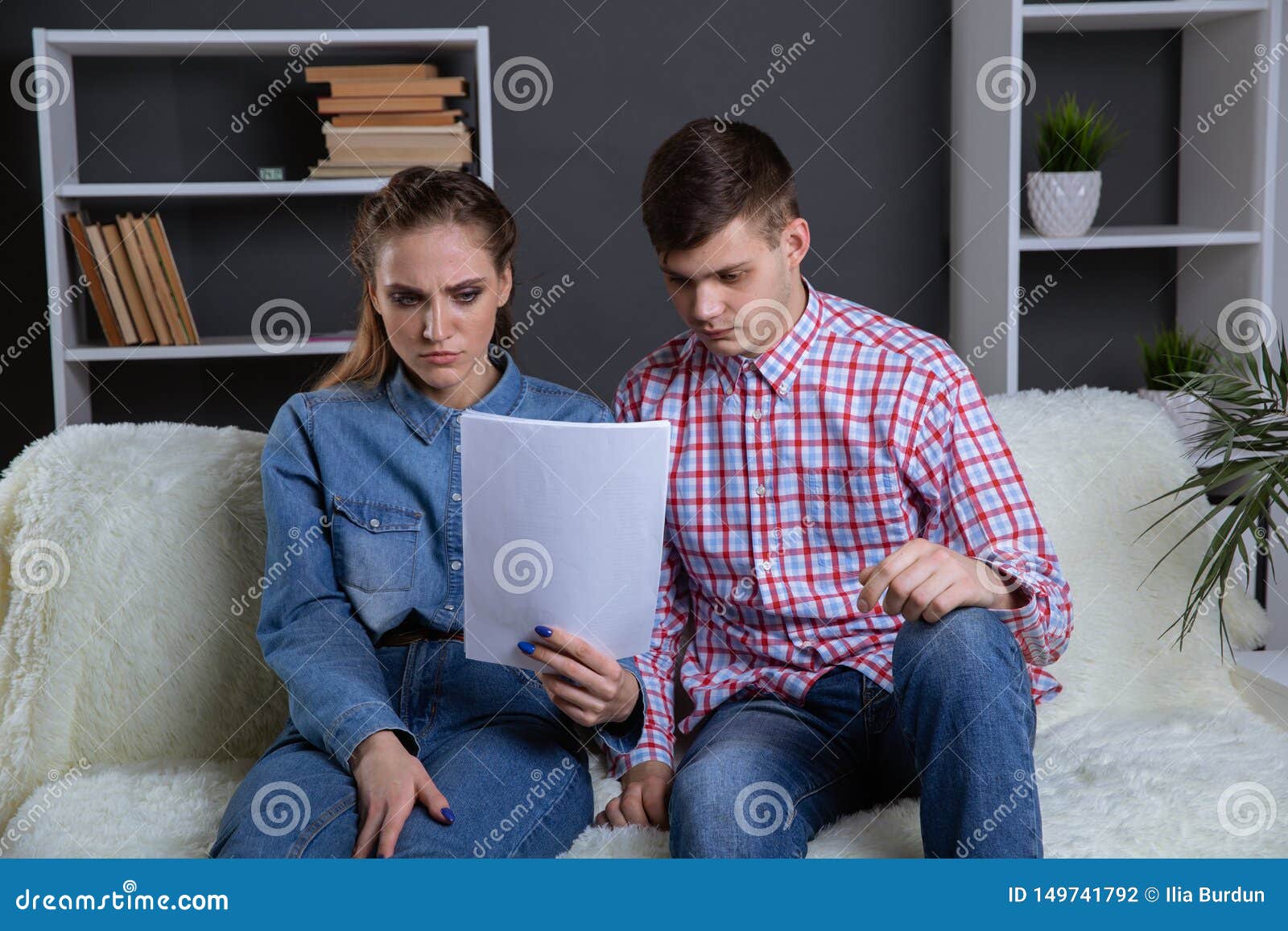 Couple Reading Documents Sitting on the Sofa at Home. Stock Photo ...