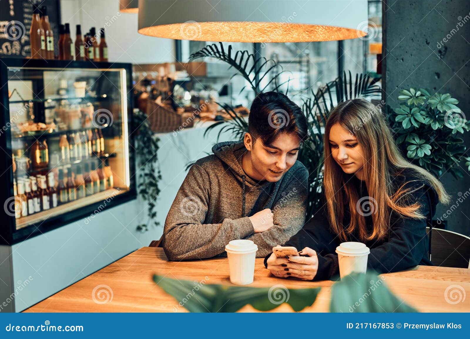 Couple Relaxing in a Cafe, Using Smartphone, Having a Chat, Talking ...
