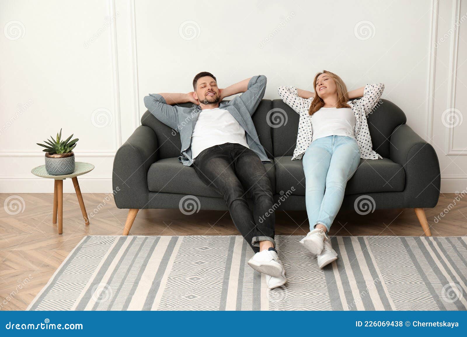 Couple Relaxing on Sofa in Room Stock Photo - Image of living, carefree ...