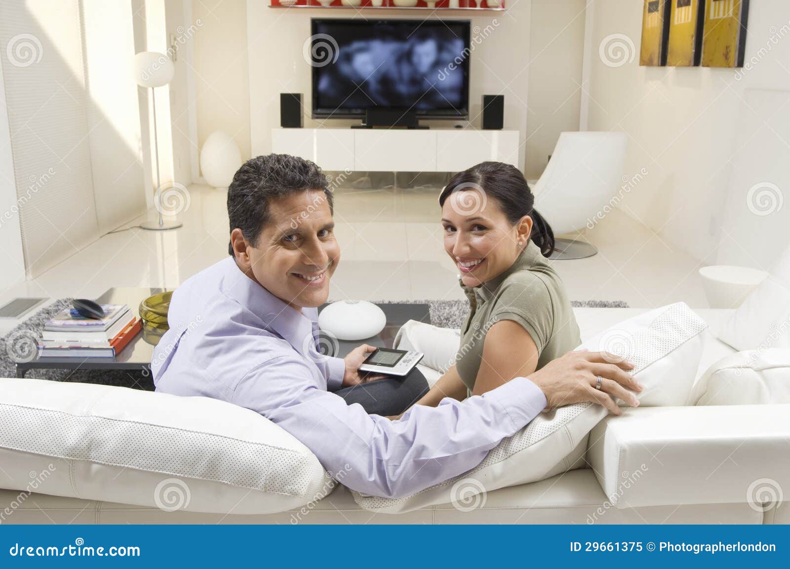 Couple with Remote Control Sitting on Sofa Stock Image - Image of ...