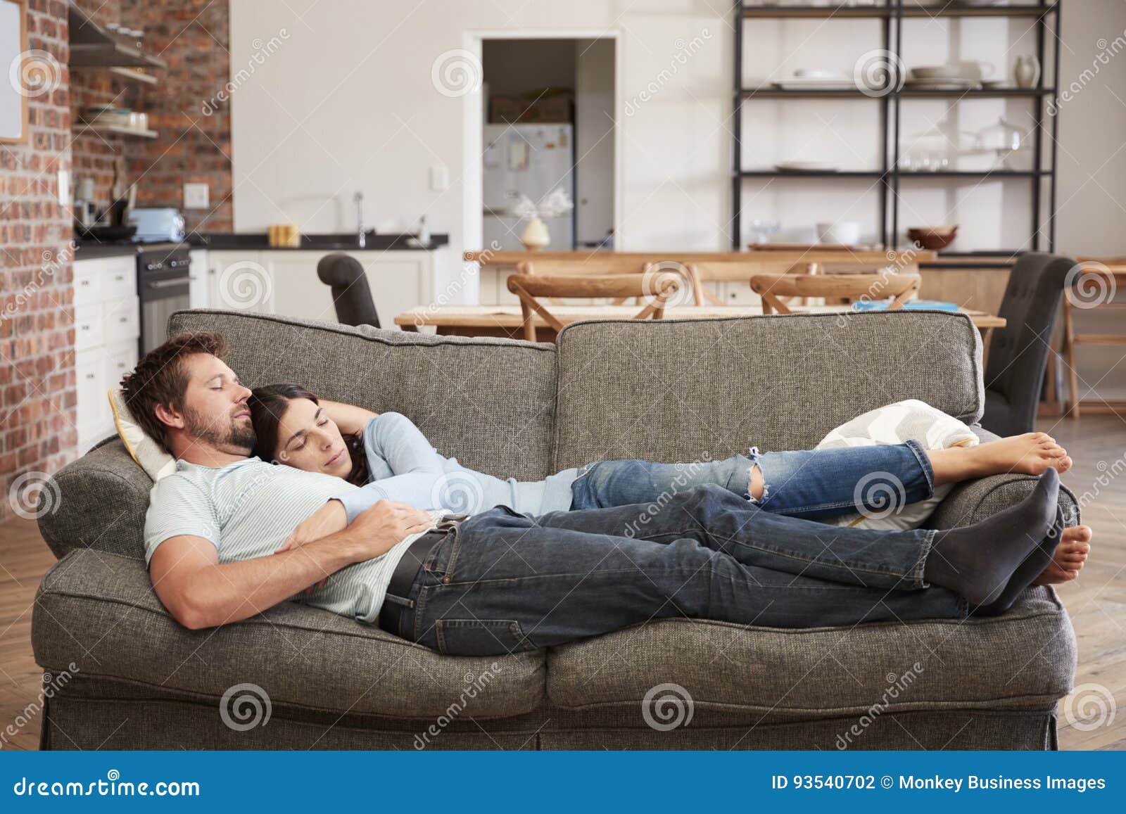 Couple Resting on Sofa in Open Plan Lounge Stock Photo - Image of ...