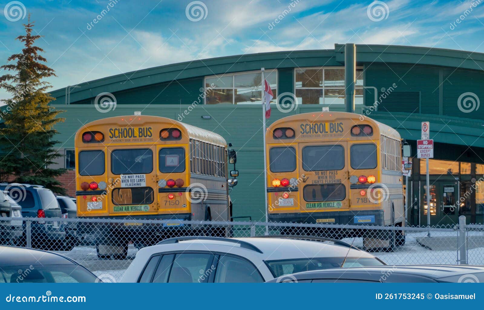 A Couple of School Buses in Front of an School during the Winter Time ...