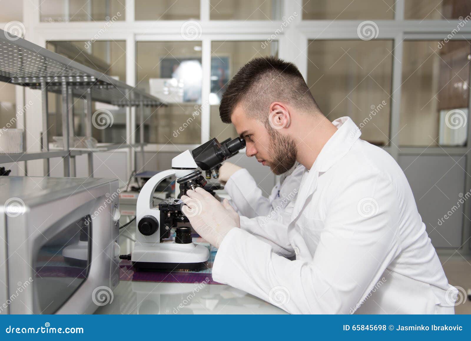 Couple of Scientists Looking into a Microscope Stock Photo - Image of ...